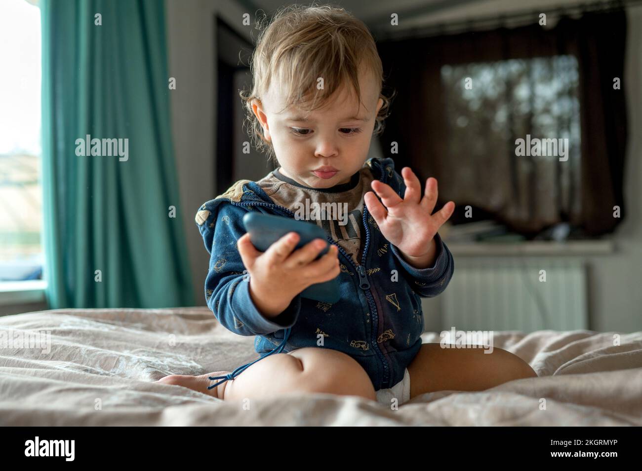 Cute boy playing phone hi-res stock photography and images - Alamy