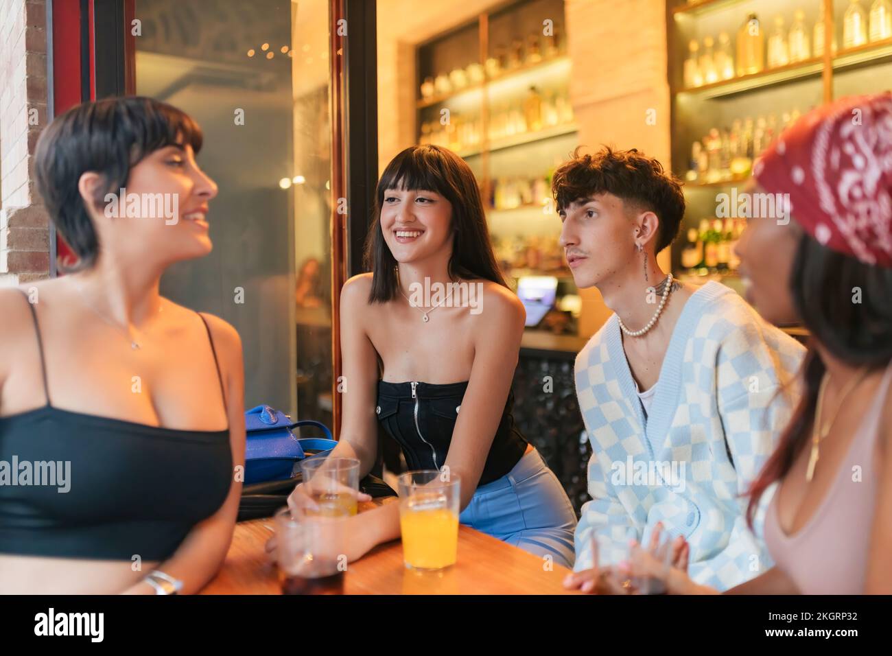 Smiling friends talking in restaurant Stock Photo - Alamy