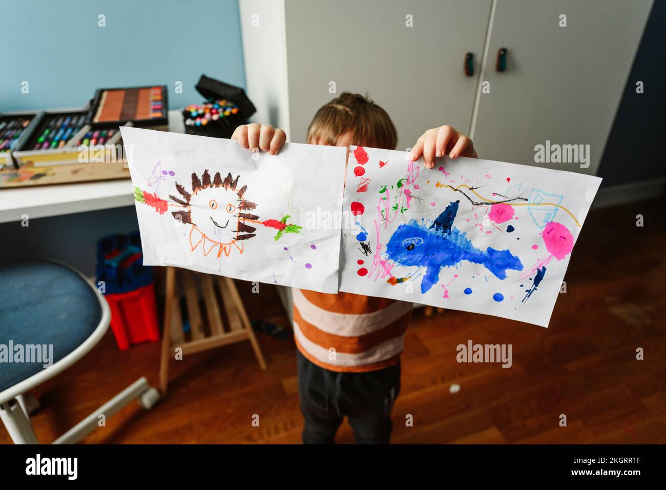 Boy showing drawing in bedroom at home Stock Photo - Alamy
