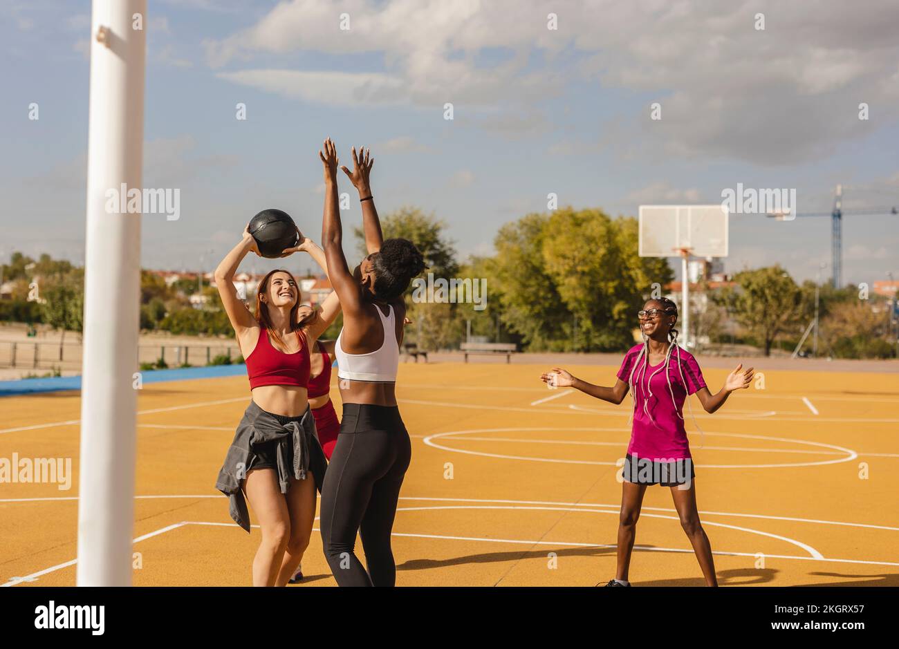 Happy friends playing basketball in sports court Stock Photo - Alamy