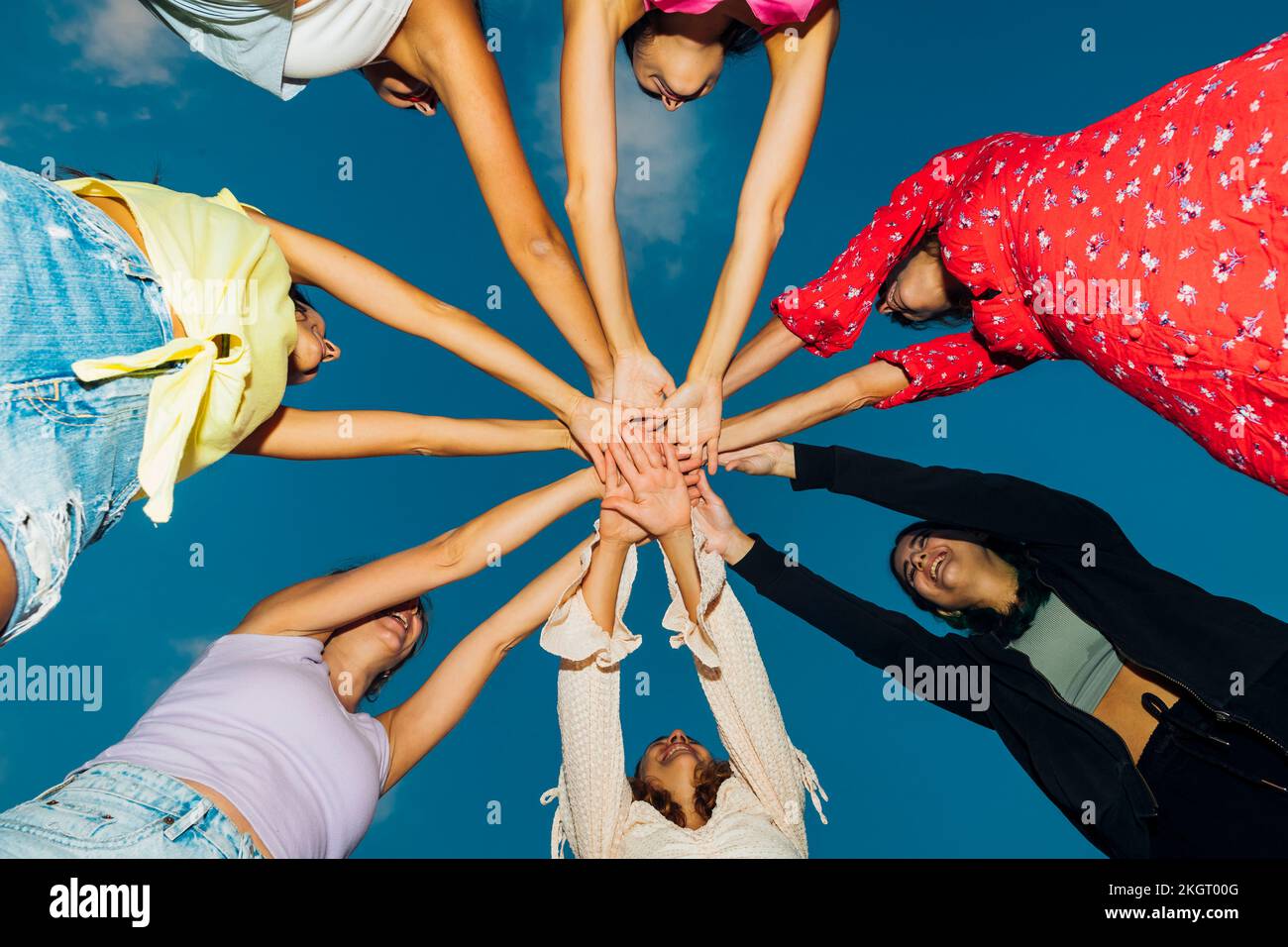 Happy female friends stacking hands at dusk Stock Photo - Alamy