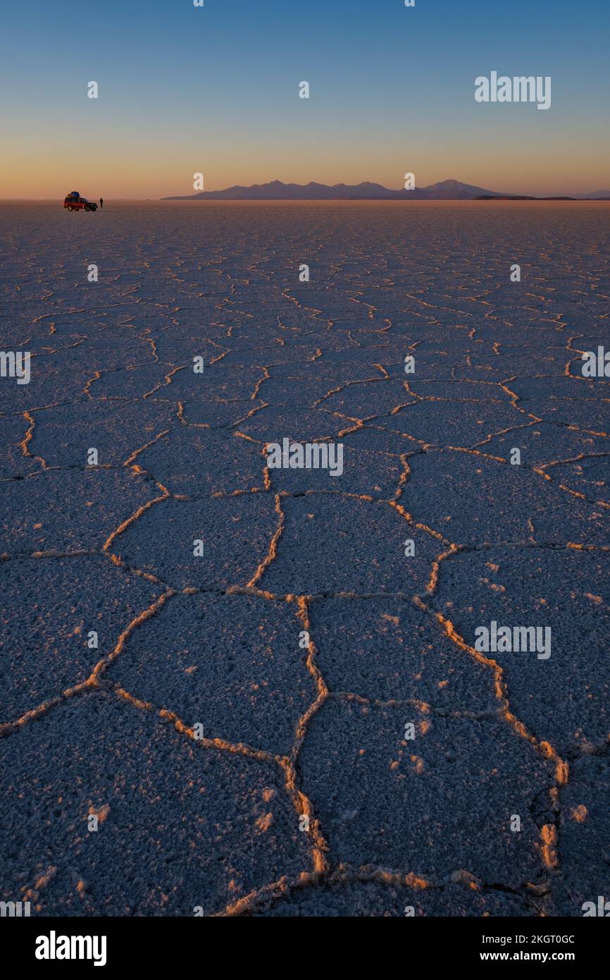 Off-road vehicle and people walking in the distance on the Salar de ...
