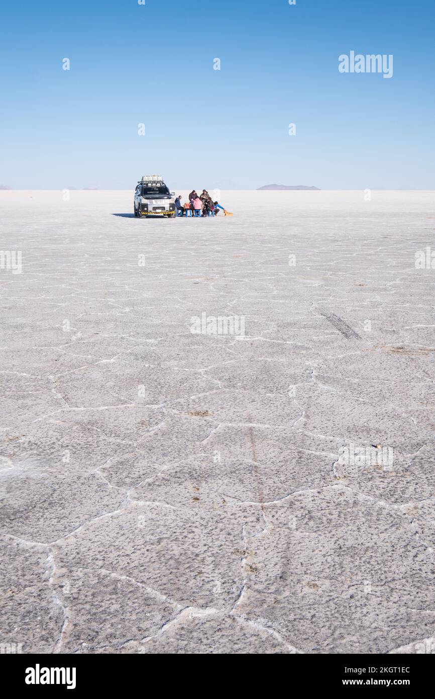 Off-road vehicle and people enjoying the day on the Salar de Uyuni ...