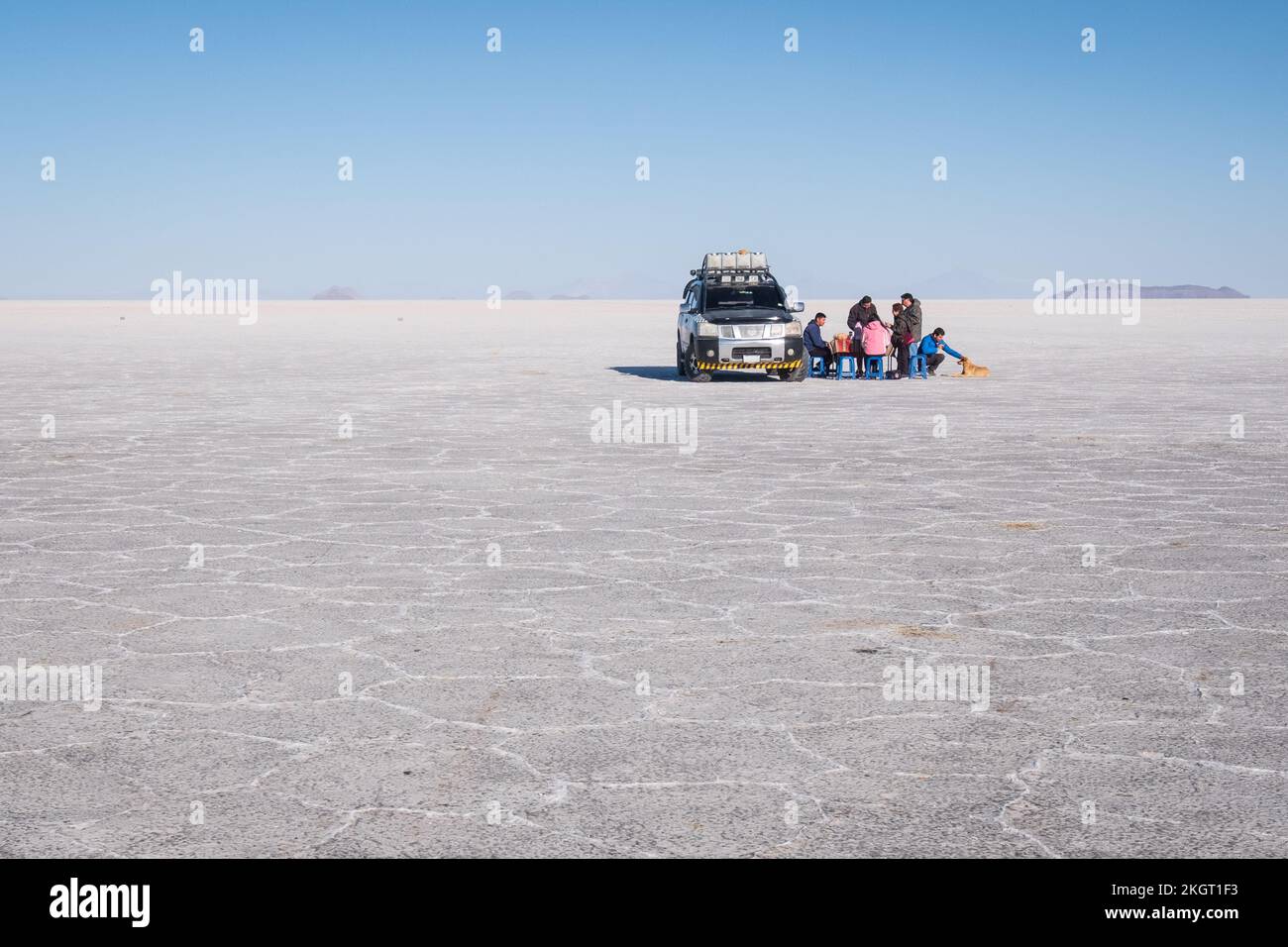 Off-road vehicle and people enjoying the day on the Salar de Uyuni ...