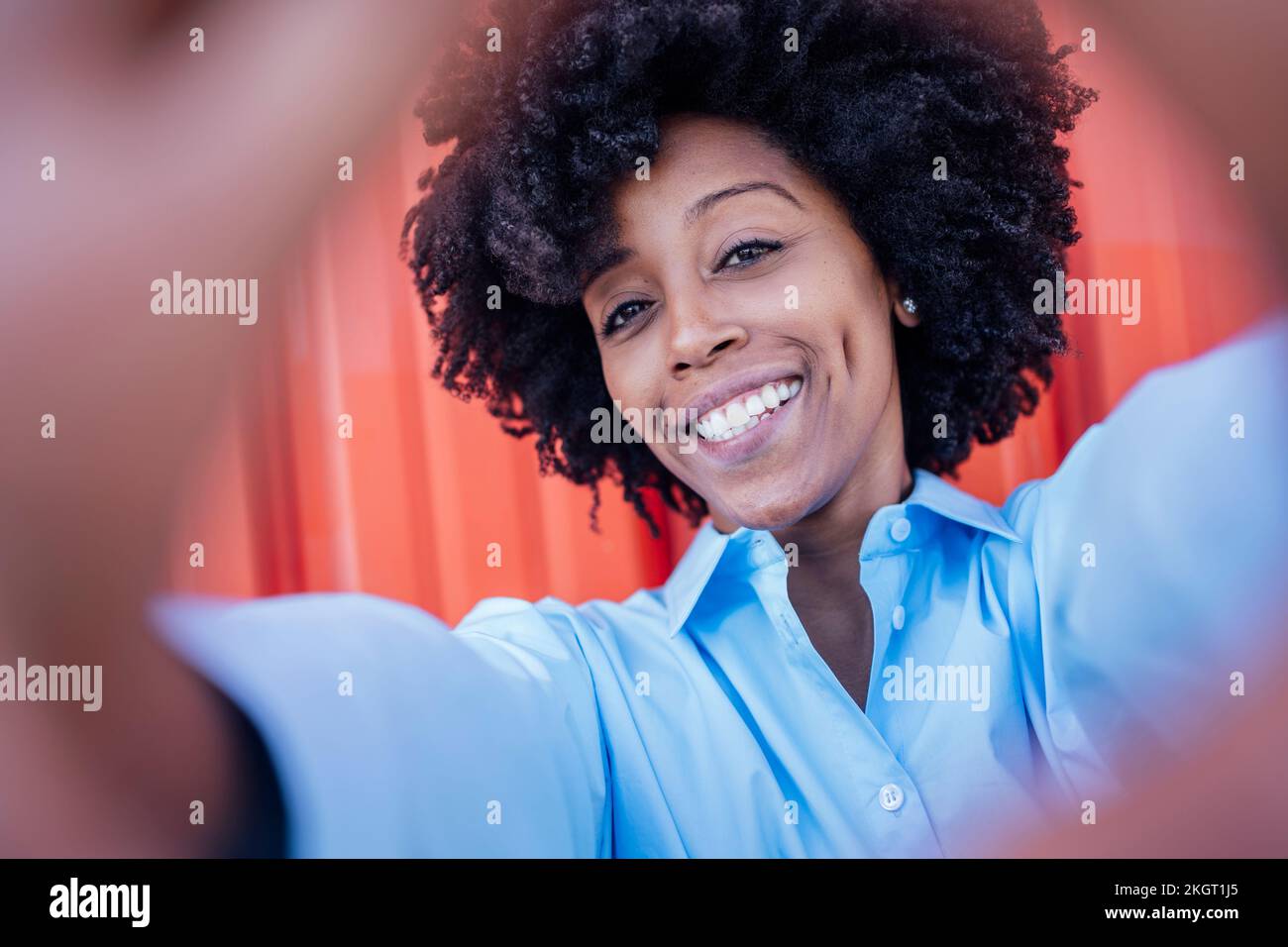 Happy young woman taking selfie in front of wall Stock Photo - Alamy