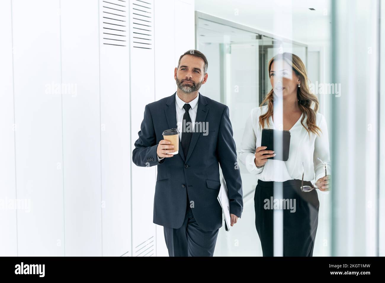 Business people walking in office corridor Stock Photo - Alamy