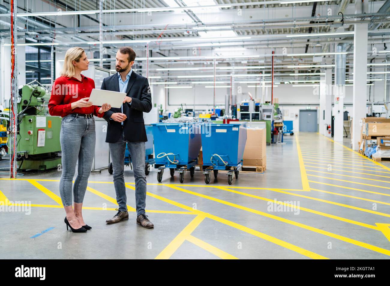 Business colleagues discussing with each other standing by markings in ...