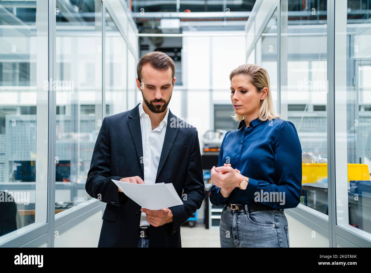 Business colleagues reviewing documents at factory Stock Photo - Alamy