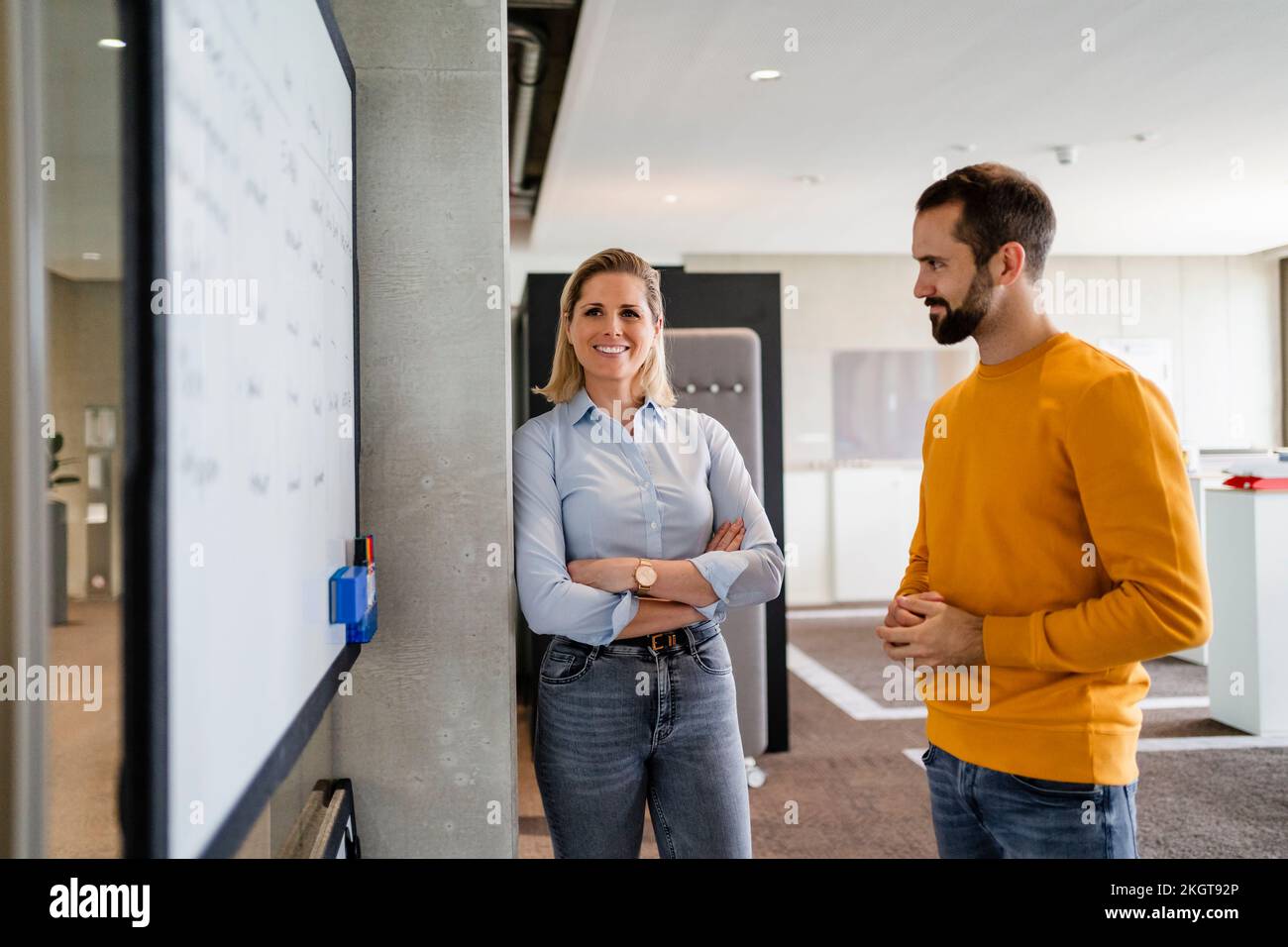 Happy colleagues standing near whiteboard at workplace Stock Photo - Alamy