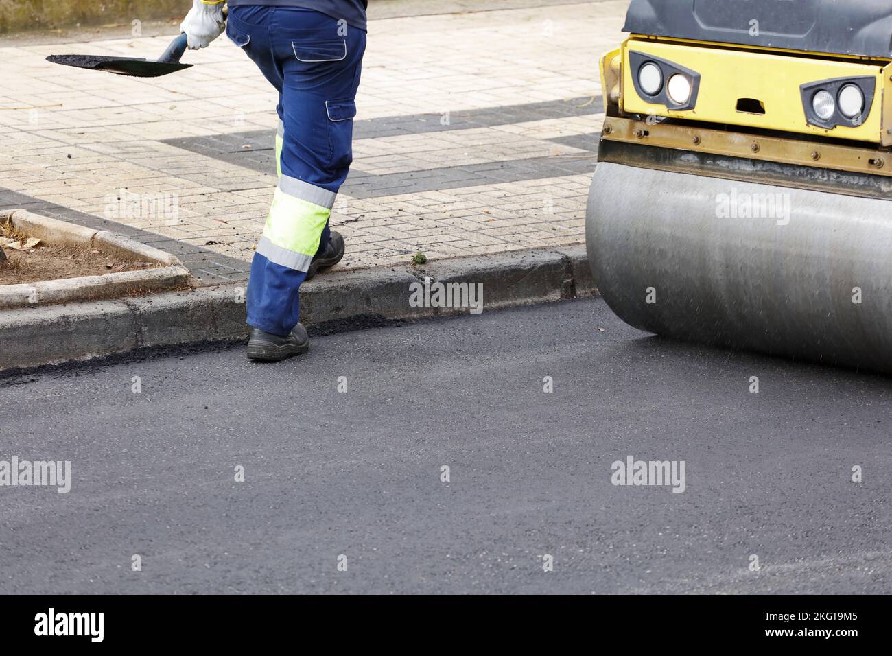 operator and road paving machine, freshly laid new asphalt Stock Photo ...