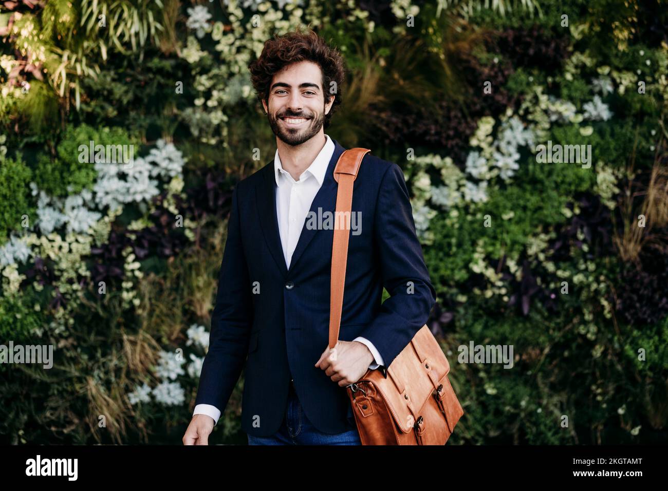Smiling man carrying plants in the field Stock Photo - Alamy