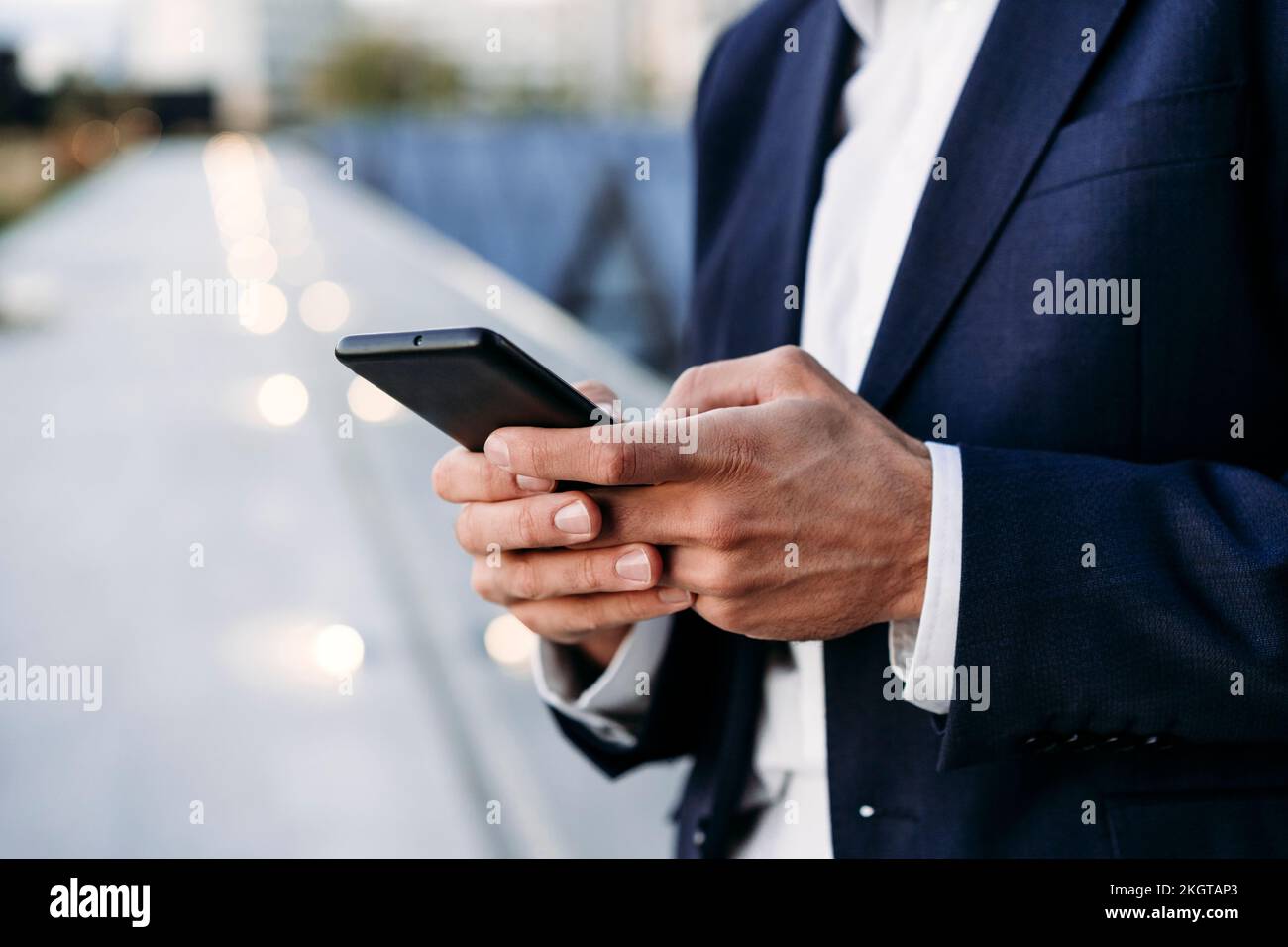Hands of businessman text messaging through smart phone Stock Photo - Alamy