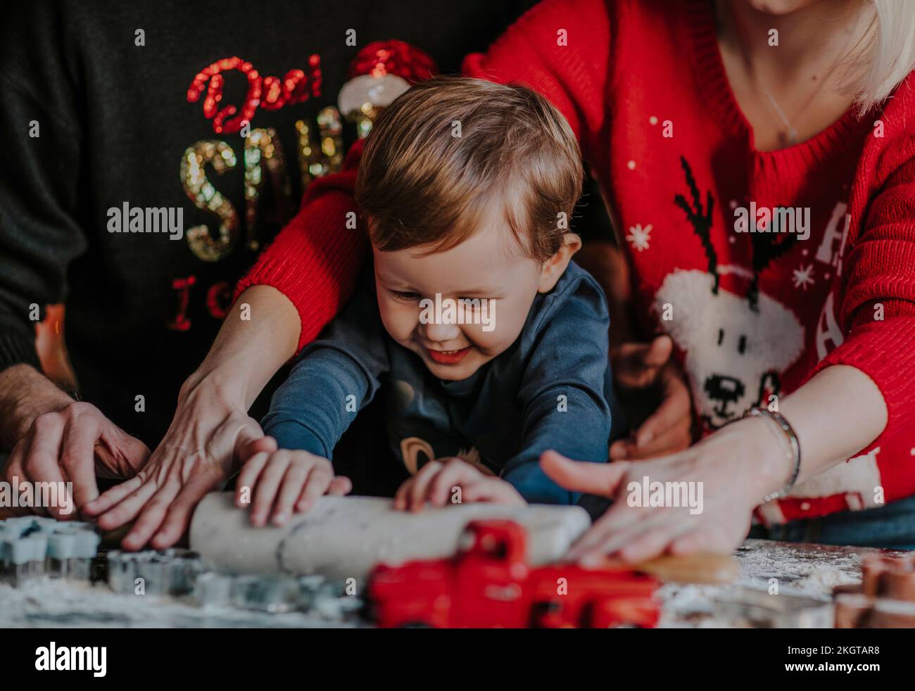 Smiling boy making cookies with father and mother in kitchen Stock ...