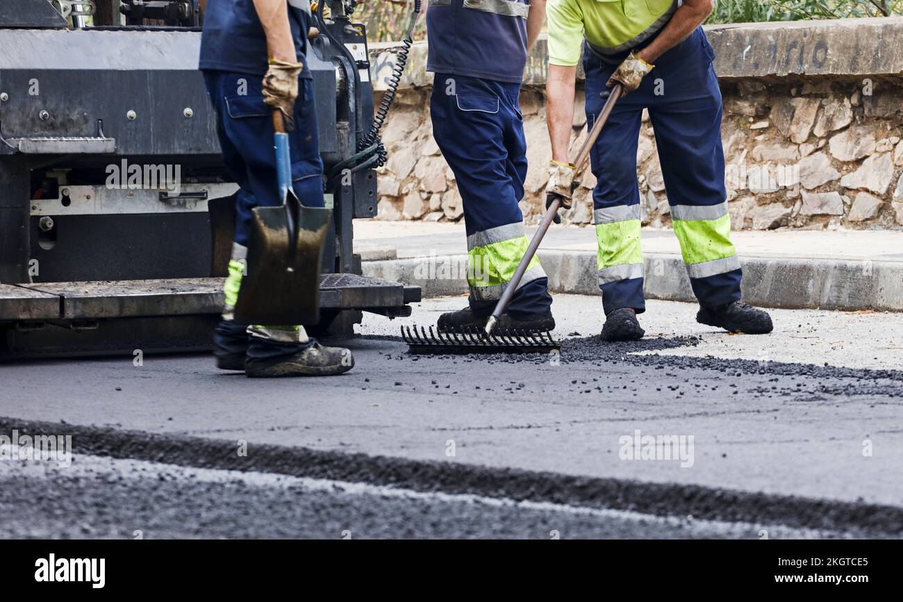 operators and road paving machines, freshly laid new asphalt Stock ...