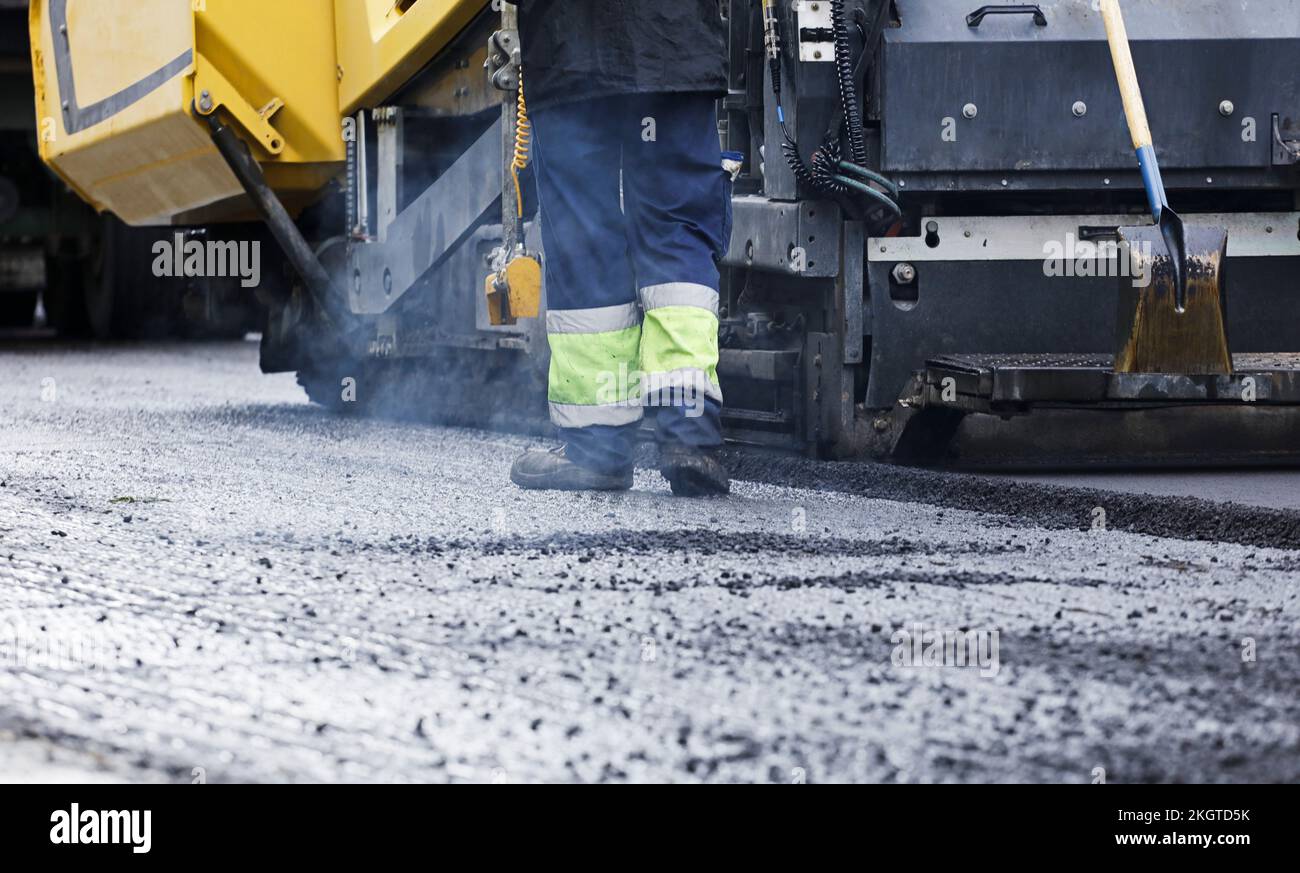 operators and road paving machines, freshly laid new asphalt Stock ...