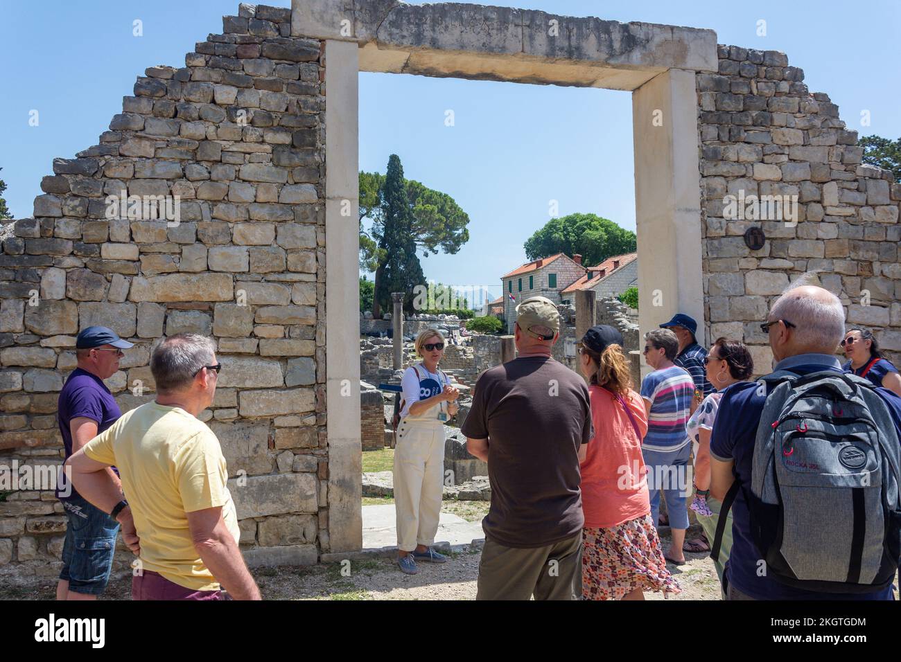 Tour guide with group at entrance gate to Early Christian Basilica and ...