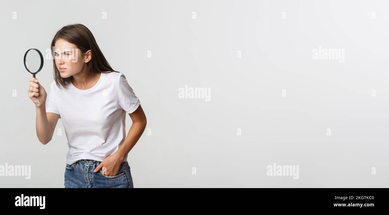 Serious-looking attractive young woman searching for something, looking ...