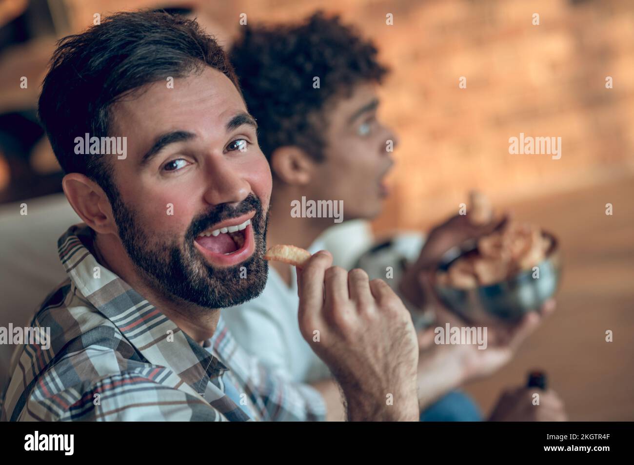 Male treating his friend with a snack Stock Photo - Alamy