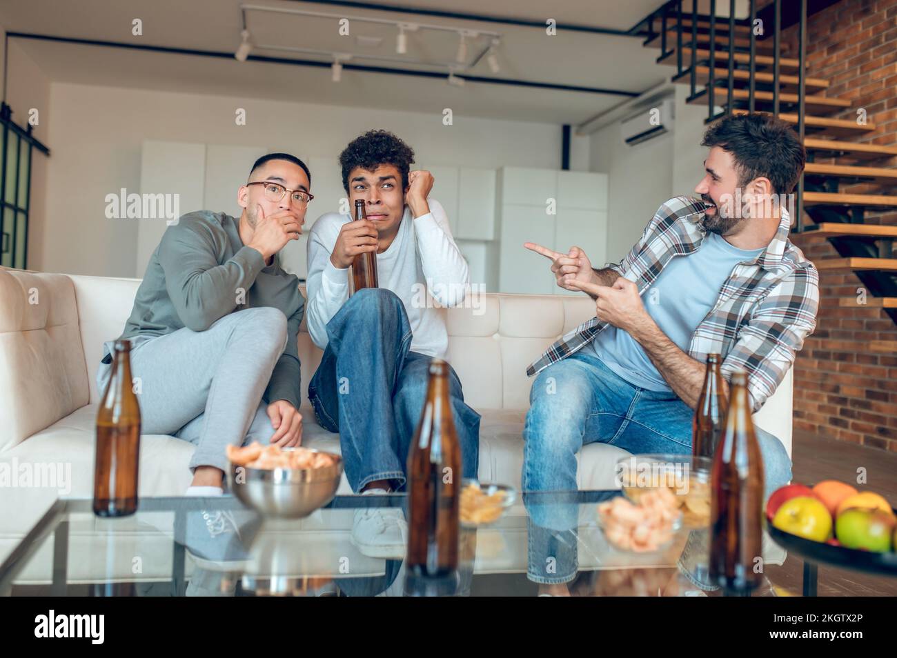 Young male mocking at his scared pals Stock Photo - Alamy