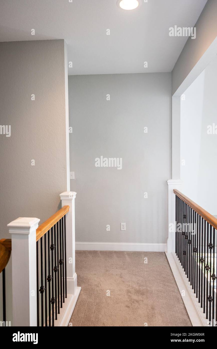 A long hallway upper level balcony with light gray modern walls Stock ...