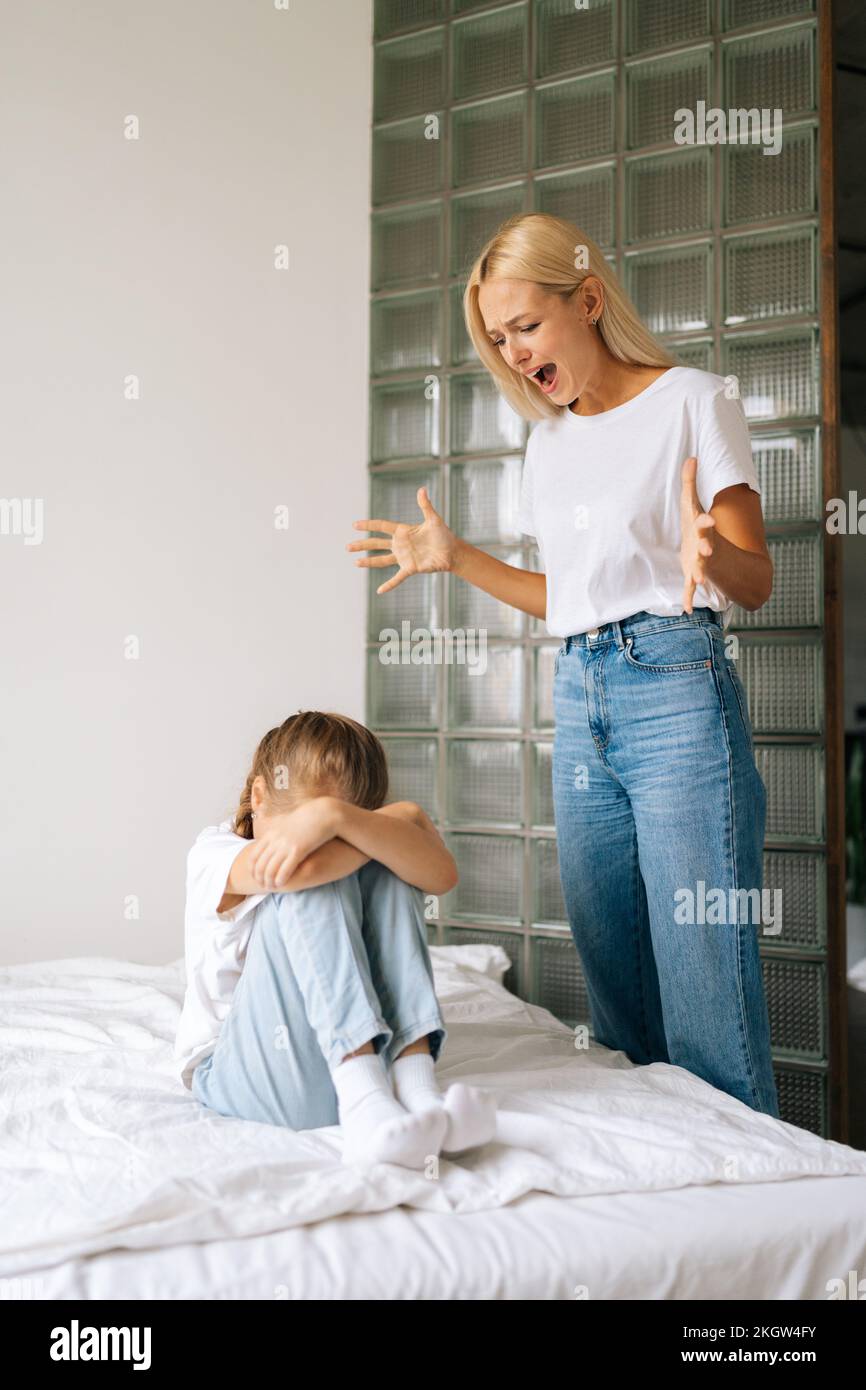 Vertical portrait of furious young mother scolding, screaming for bad ...