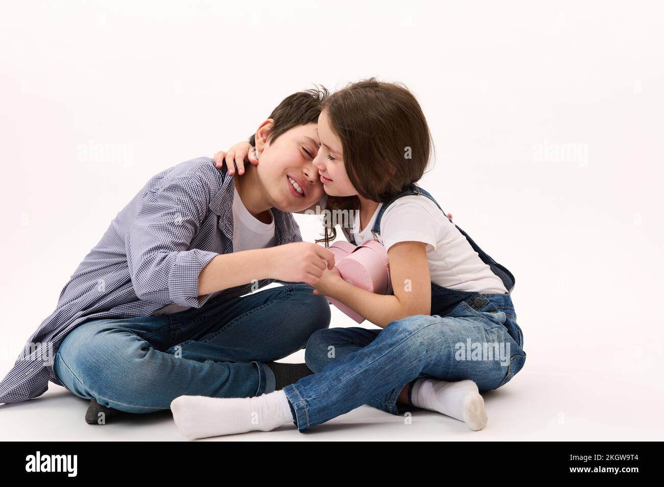 Happy little girl gently hugging her brother while receiving a cute ...