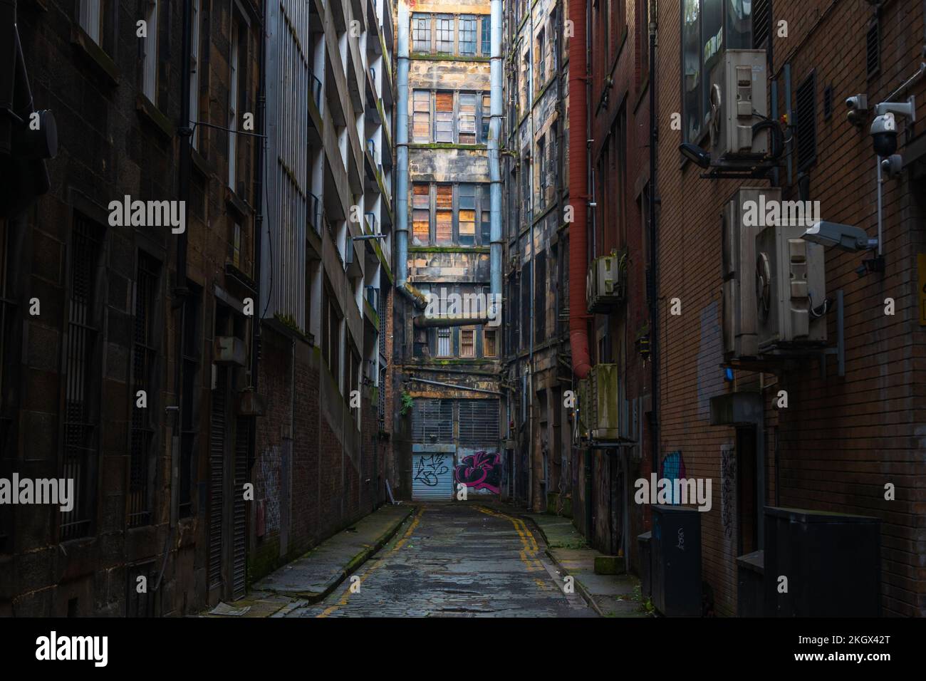 A gateway between tall old brick buildings with windows, Glasgow Stock ...