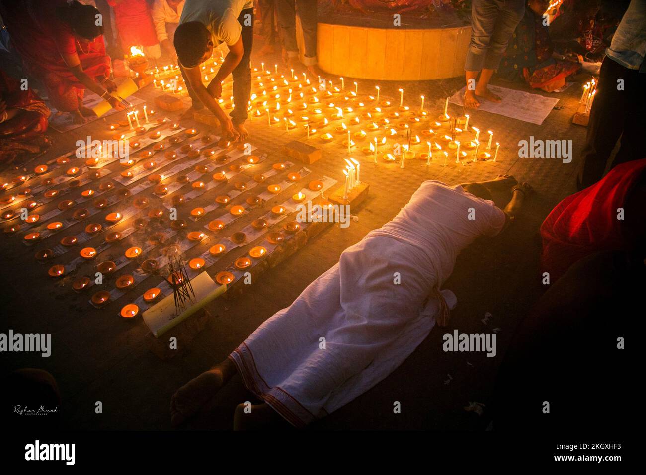 Bangladeshi Hindu devotees sit with candles and pray to God at the Shri ...