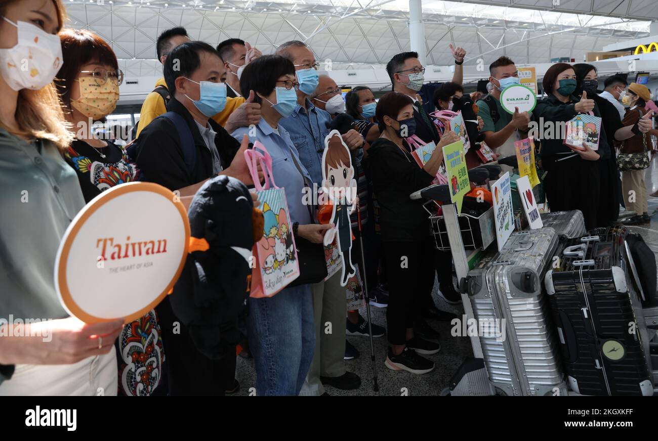 Passengers pose for a picture at the EVA Airways counter in Hong Kong ...