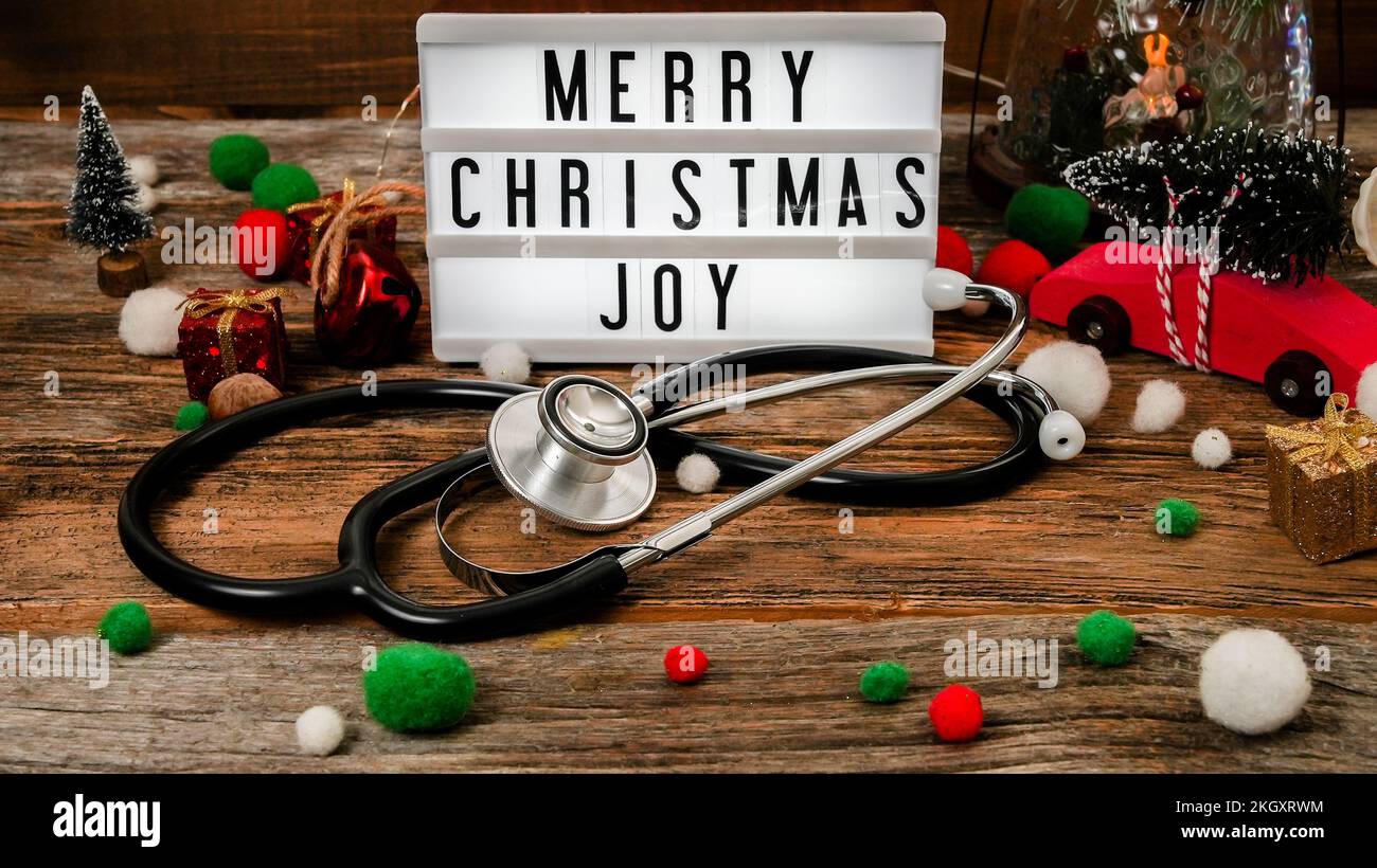 Merry Christmas light box with ornaments and stethoscope on rustic wood ...