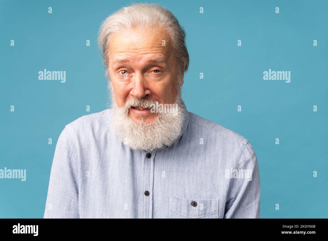Portrait of surprised grey hair beard grandfather old man over blue ...