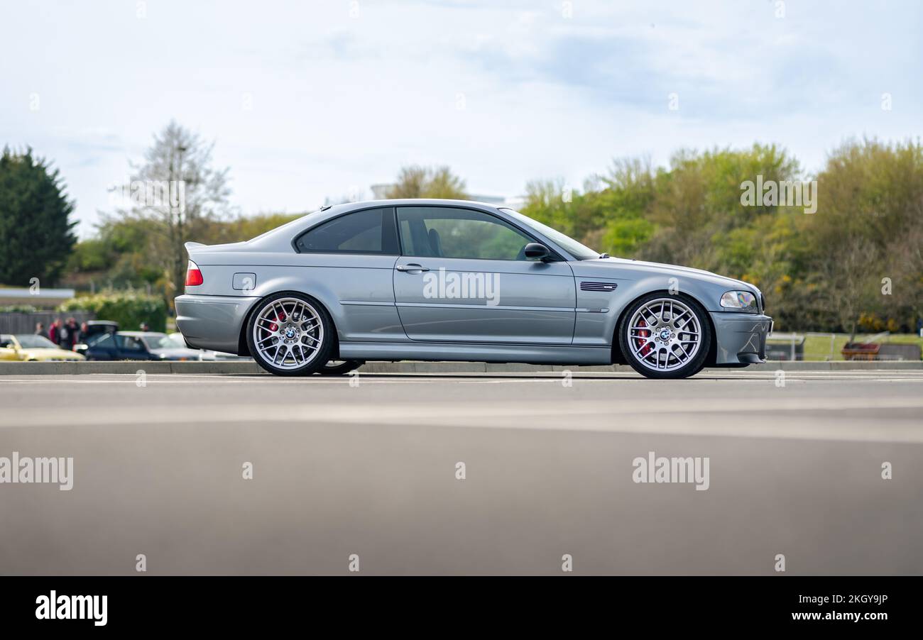 A grey modern BMW M3 CSL on the road surrounded by green trees Stock ...