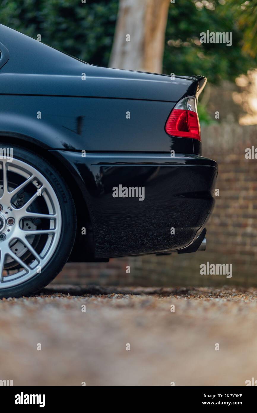 A vertical shot of the back of black modern BMW M3 CSL on the street ...