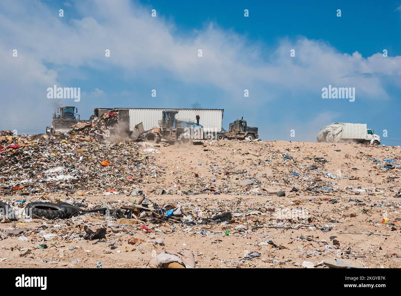 Two soil compactors, a semi tractor-trailer and a garbage truck on a ...