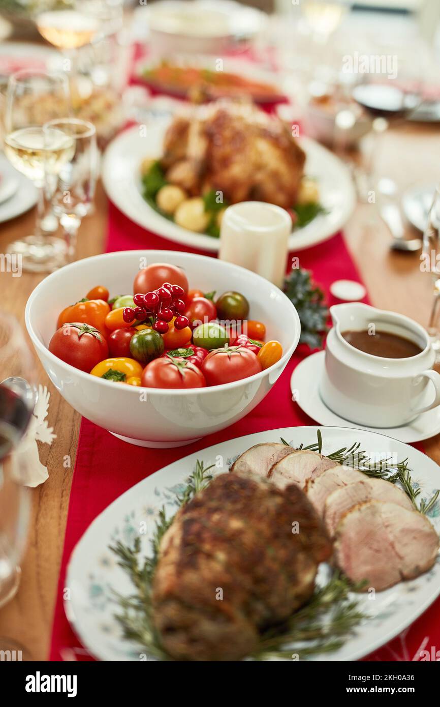 Christmas food, roast beef or tomato vegetables on dining table in empty house, home or ...