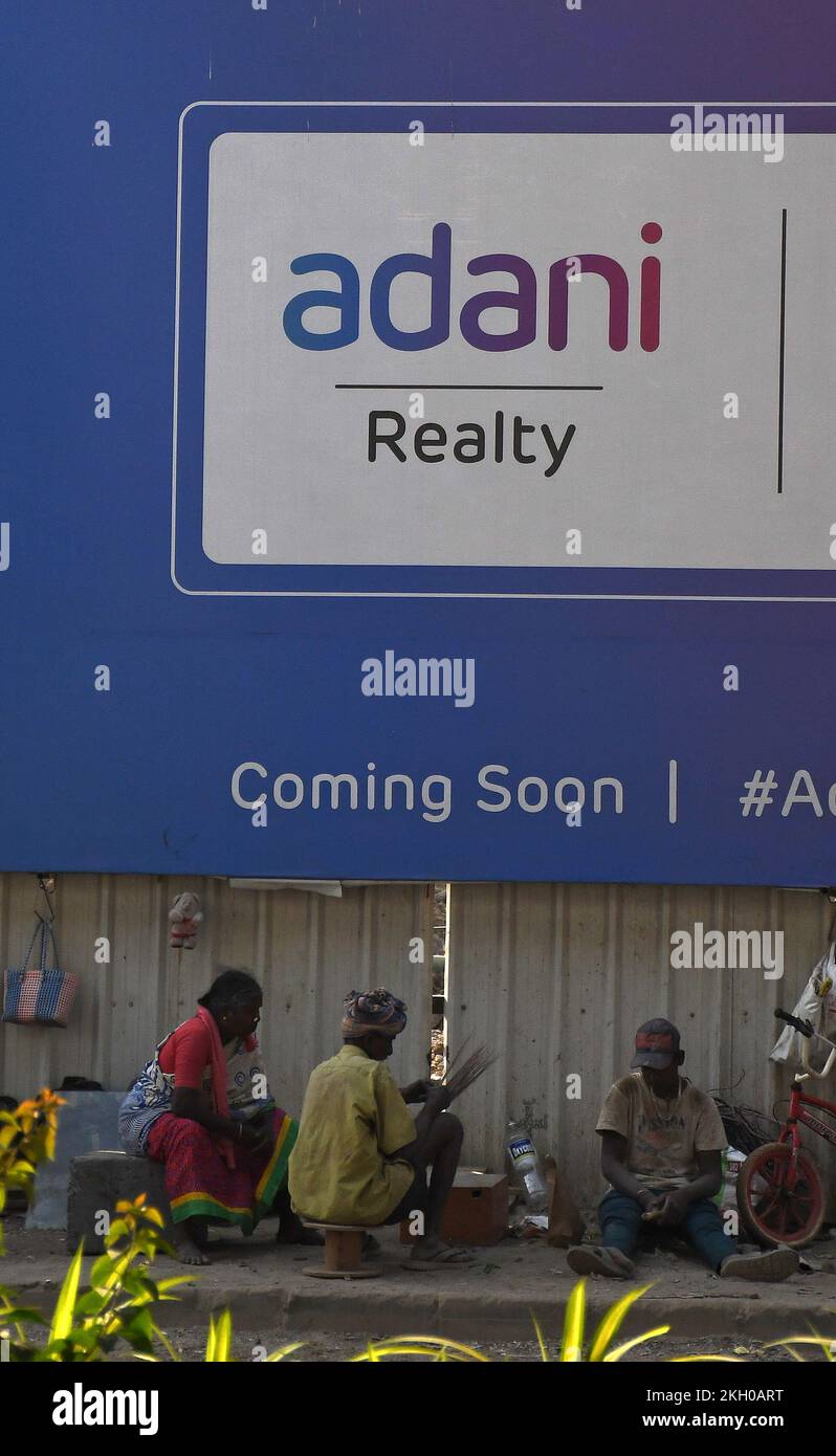 People are seen below Adani logo on a poster in Mumbai. Adani group is ...