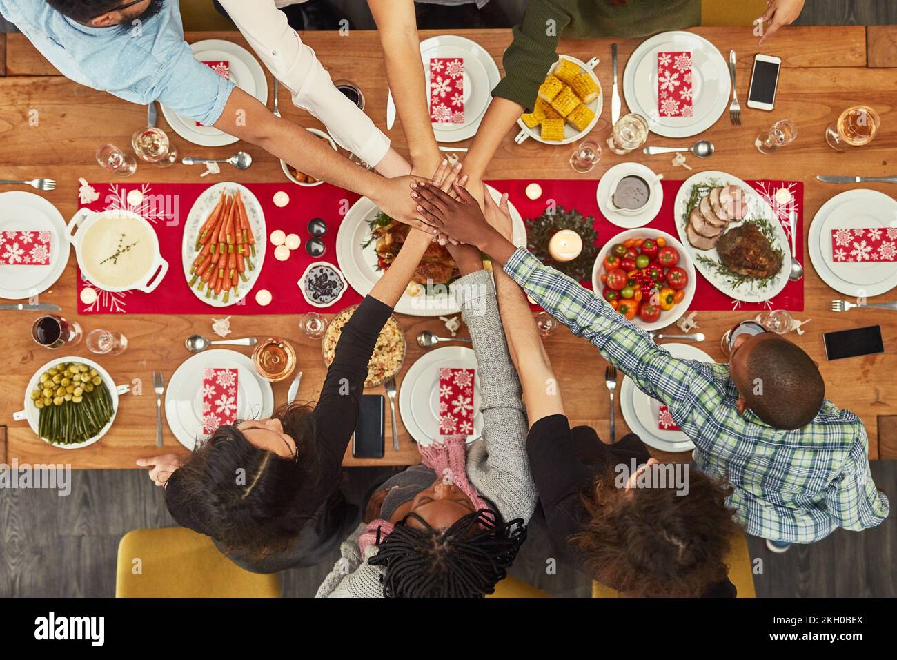 Hands, unity and Christmas with a table setting for dinner or a ...