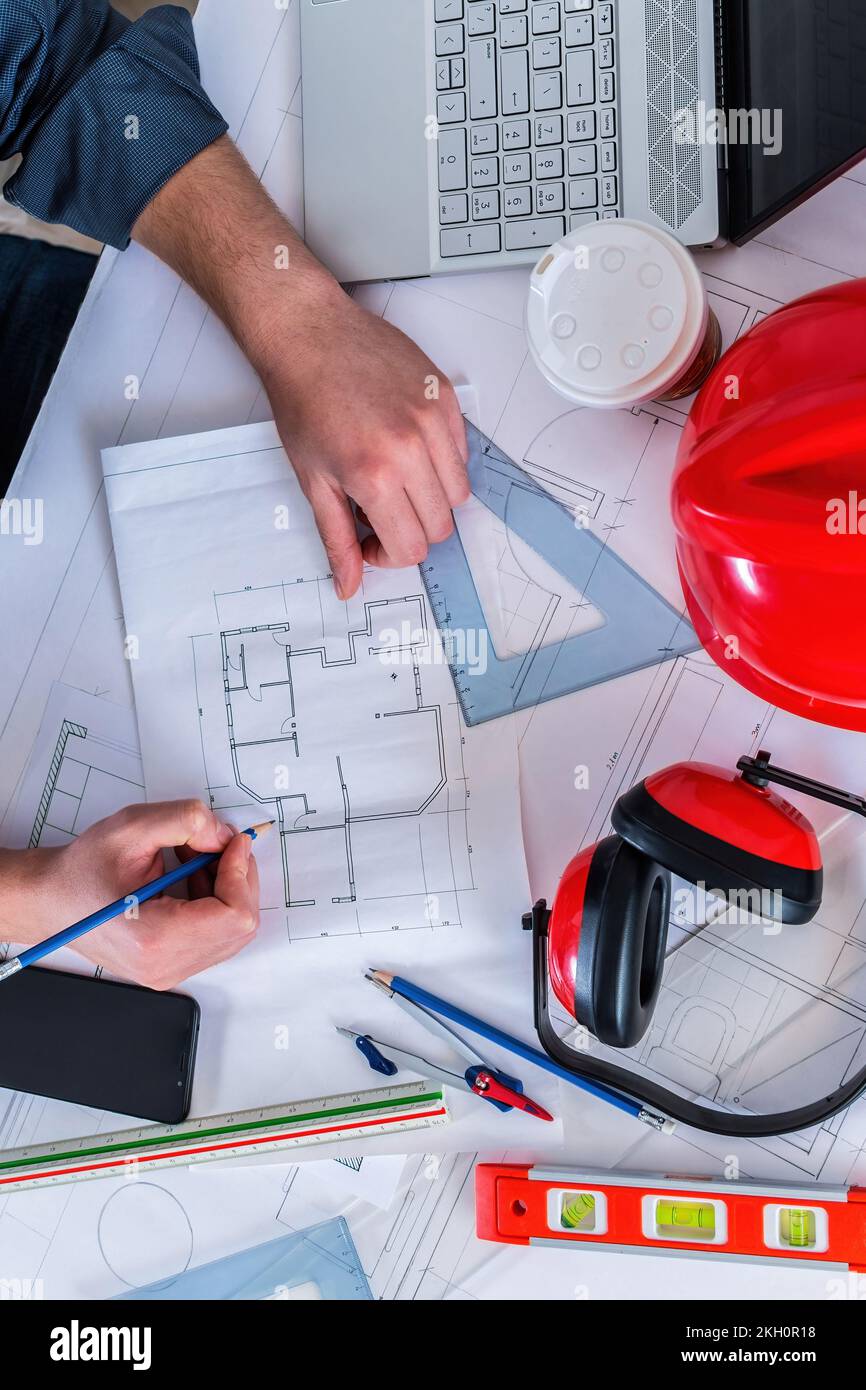 A top view of an engineer at the office desk designing a construction ...