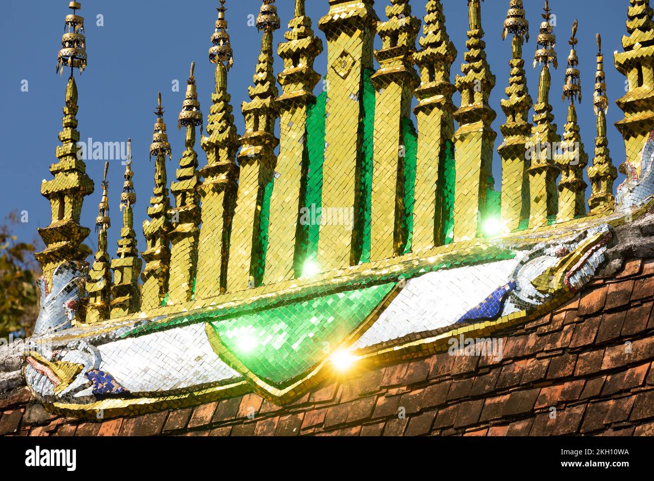 Roof topped with traditional Dok so faa, decorated with bright green glass, at Wat Xieng Thong ...