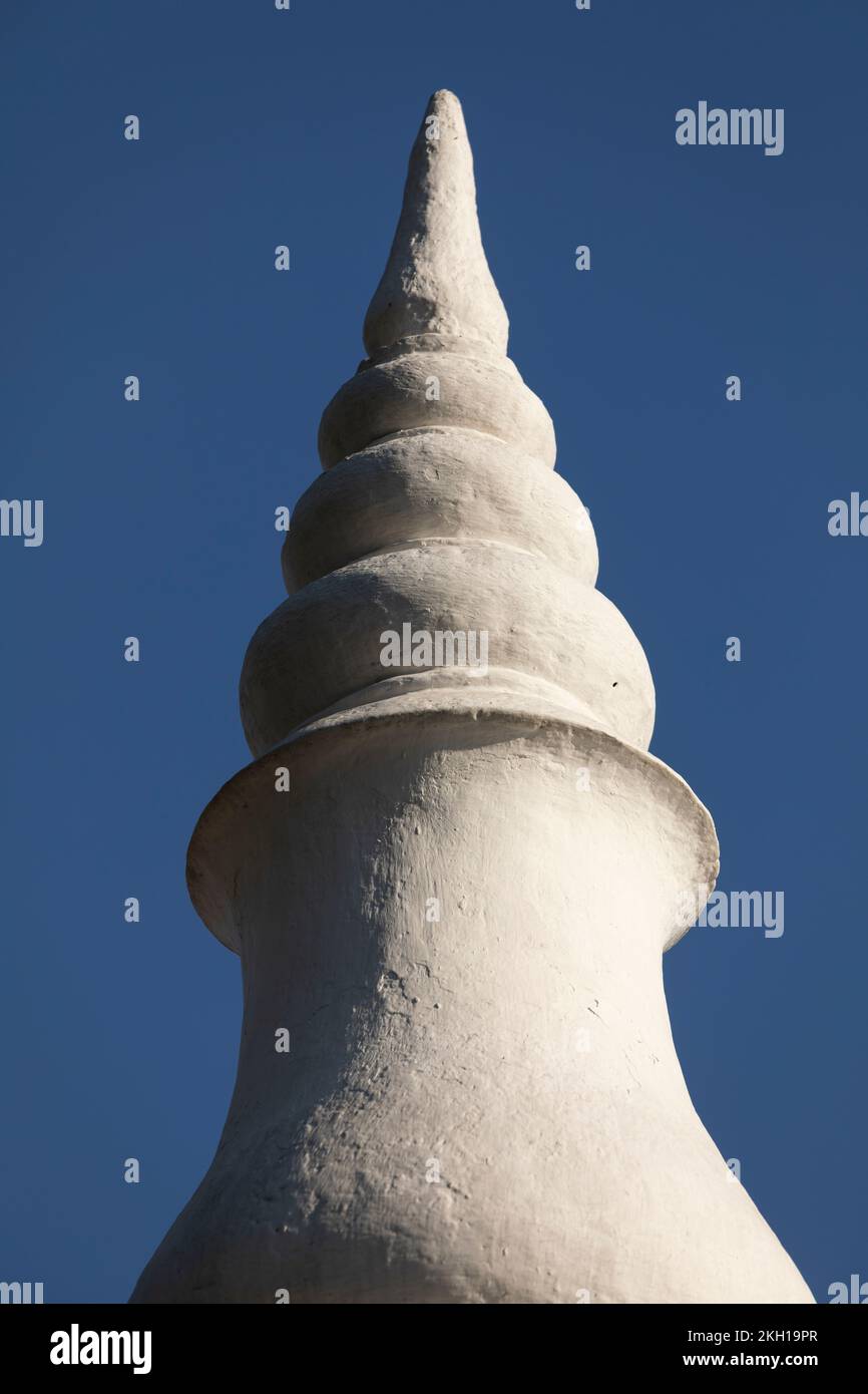 An ancient stupa painted in white, part of the opening of a gateway to ...