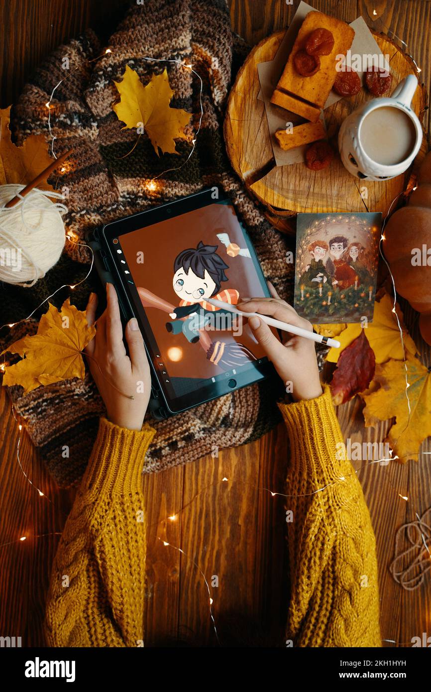 Young woman in a sweater draws on a tablet Stock Photo - Alamy