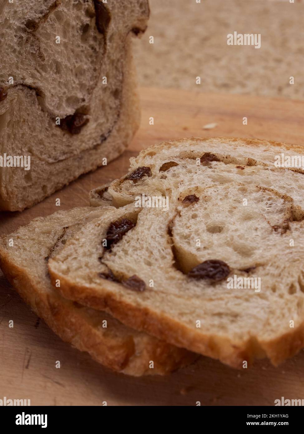 Slices of homemade cinnamon, brown sugar, raisin bread on a wooden ...
