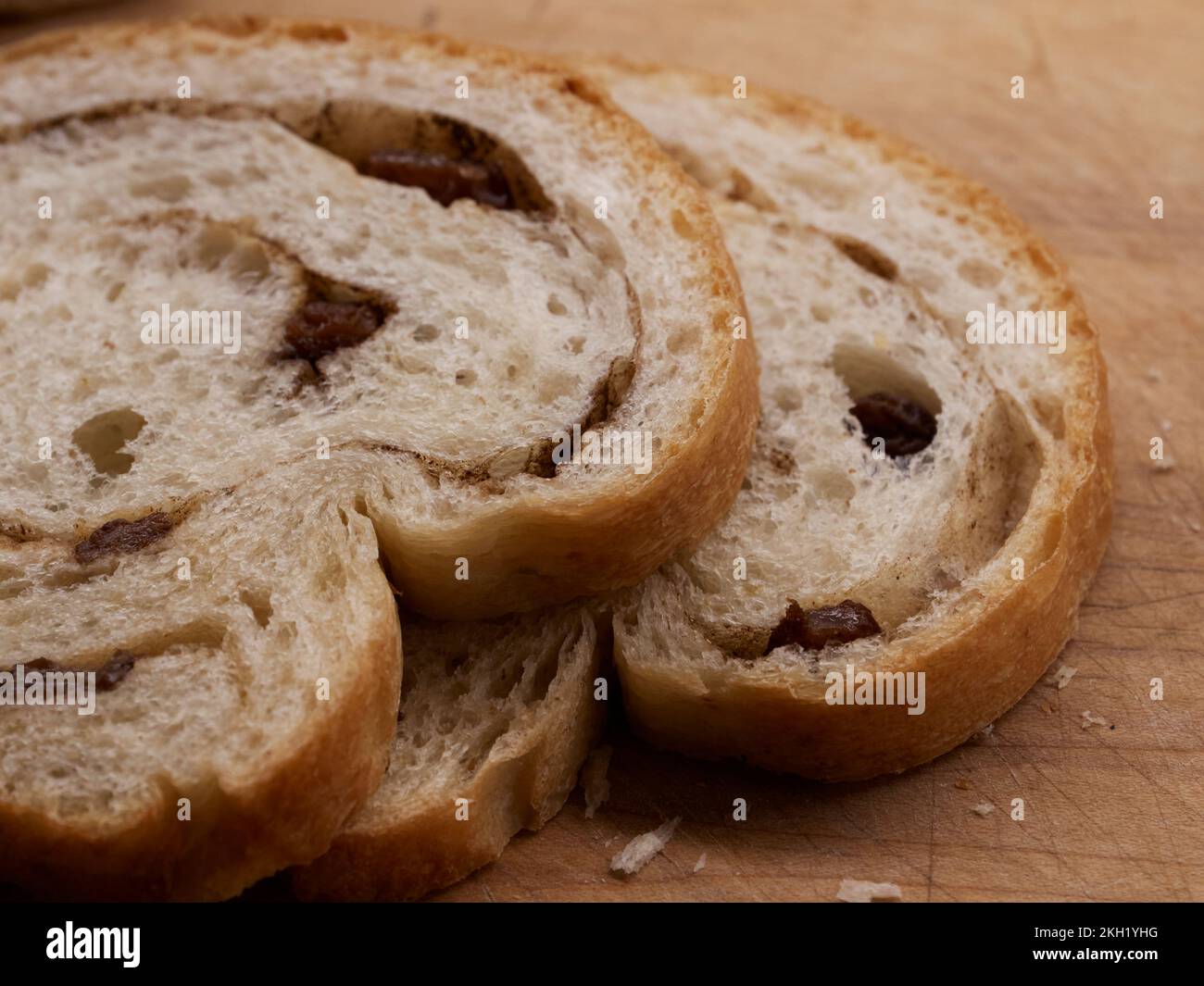 Slices of homemade cinnamon, brown sugar, raisin bread on a wooden ...
