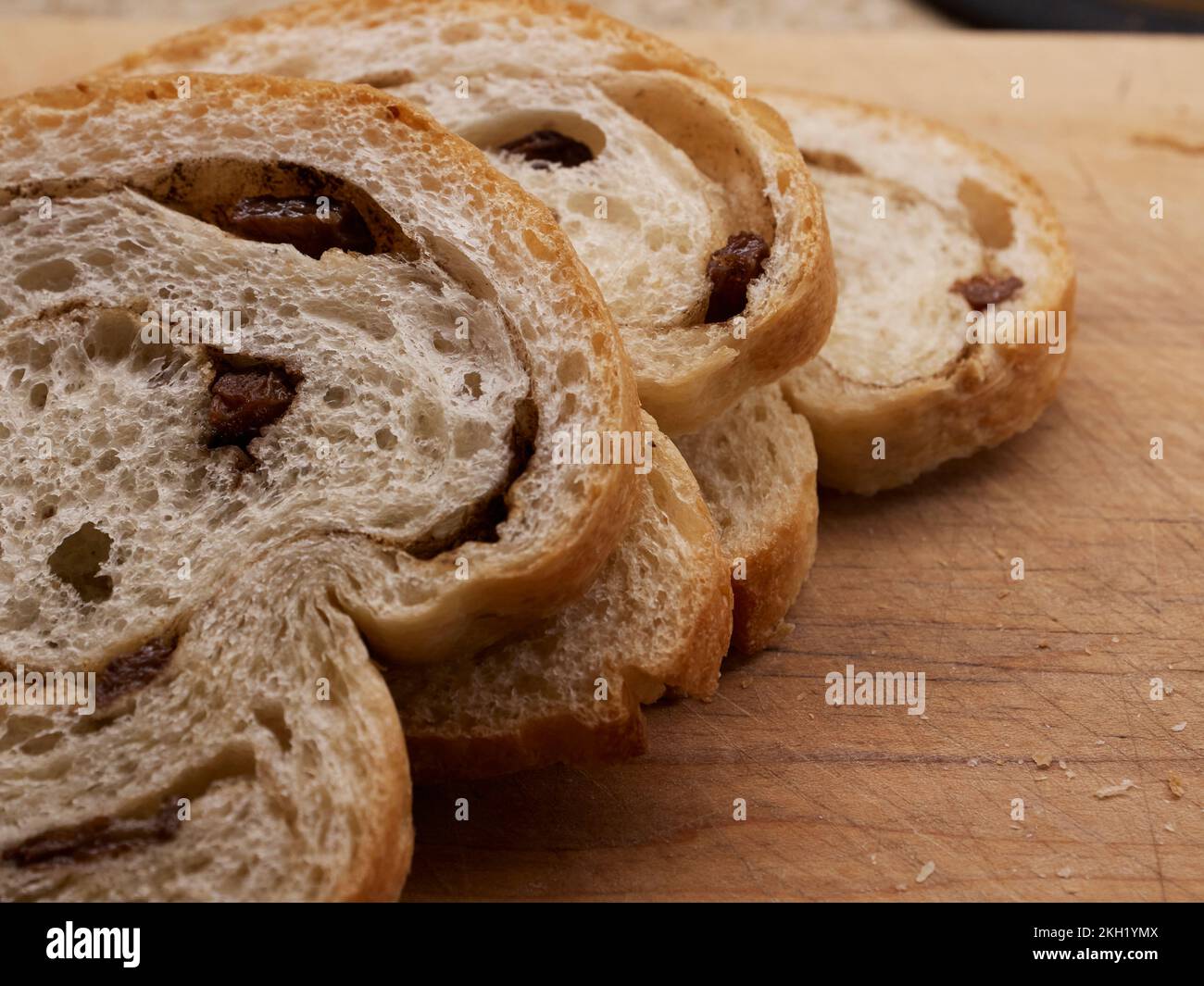 Slices of homemade cinnamon, brown sugar, raisin bread on a wooden ...