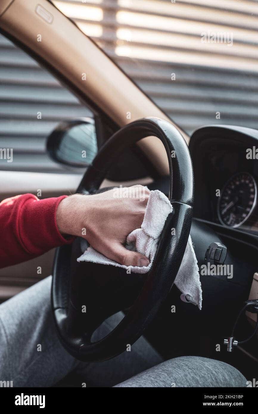 A vertical shot of a young boy cleaning his car. A boy taking care of ...