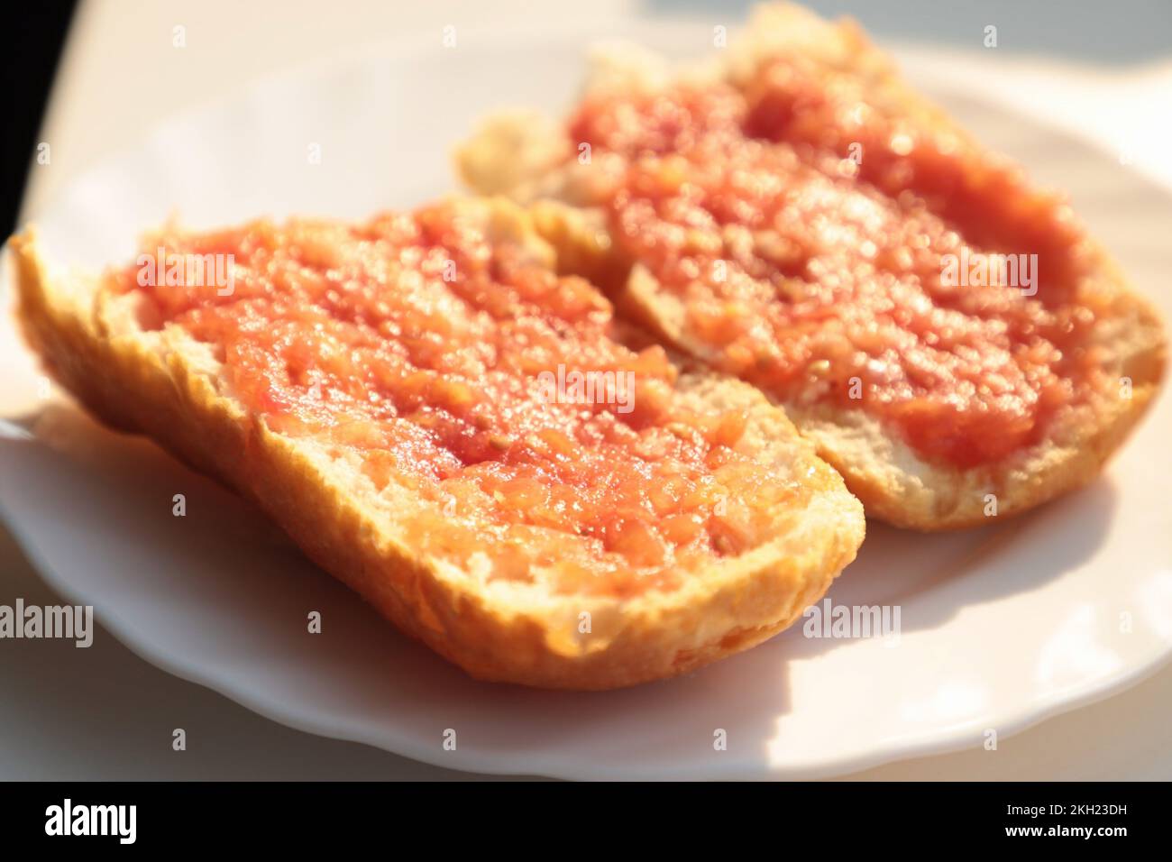 A closeup of a Mediterranean breakfast of toast with tomato, oil and ...