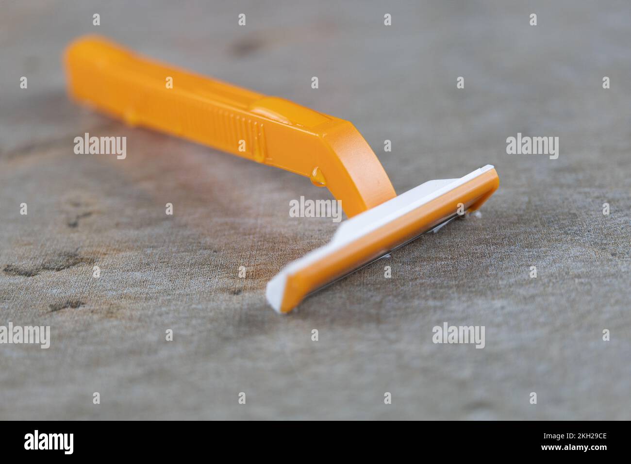 orange razor on wet bathroom surface Stock Photo - Alamy