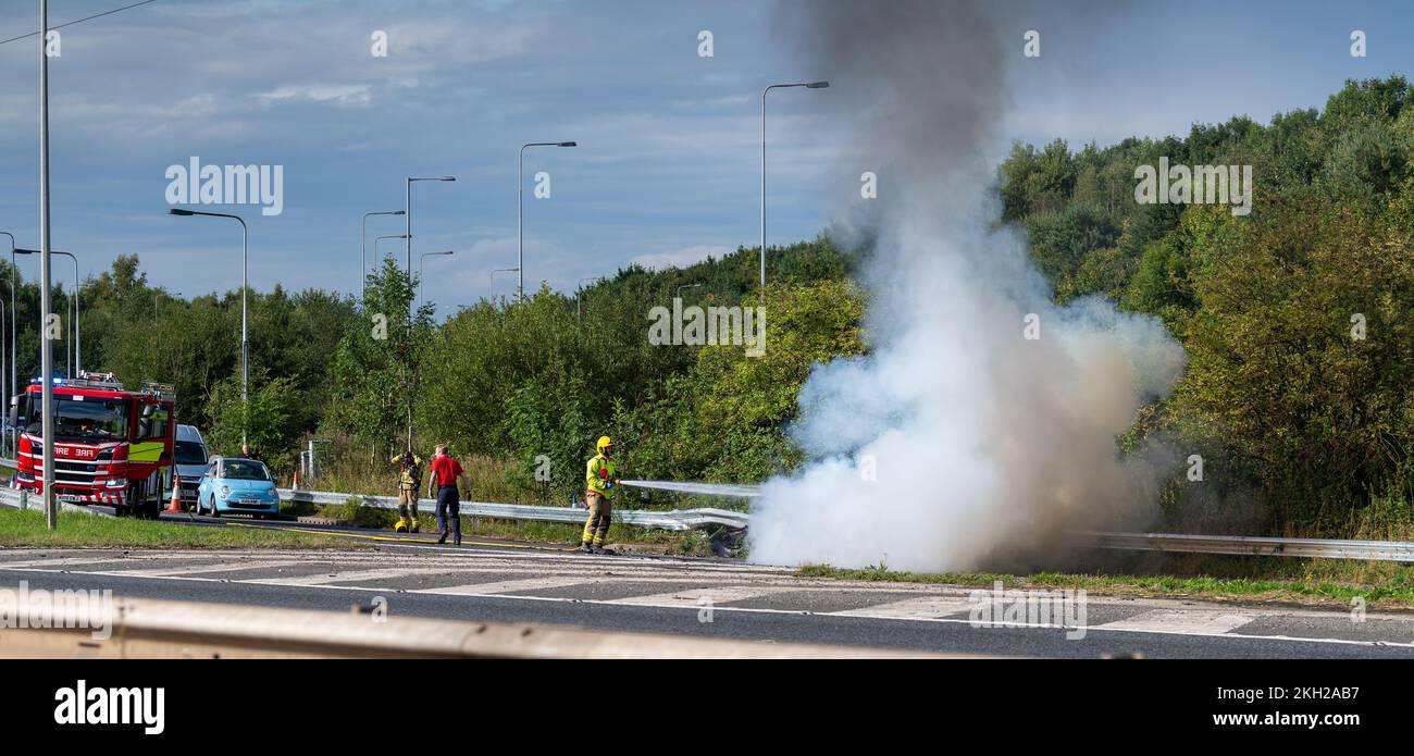 Fire crew putting out a car fire after an incident on the Motorway, UK ...