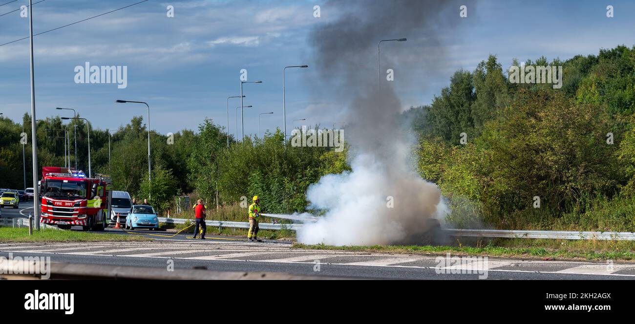 Fire crew putting out a car fire after an incident on the Motorway, UK ...