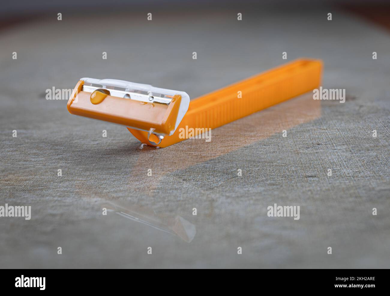 orange razor on wet bathroom surface Stock Photo - Alamy